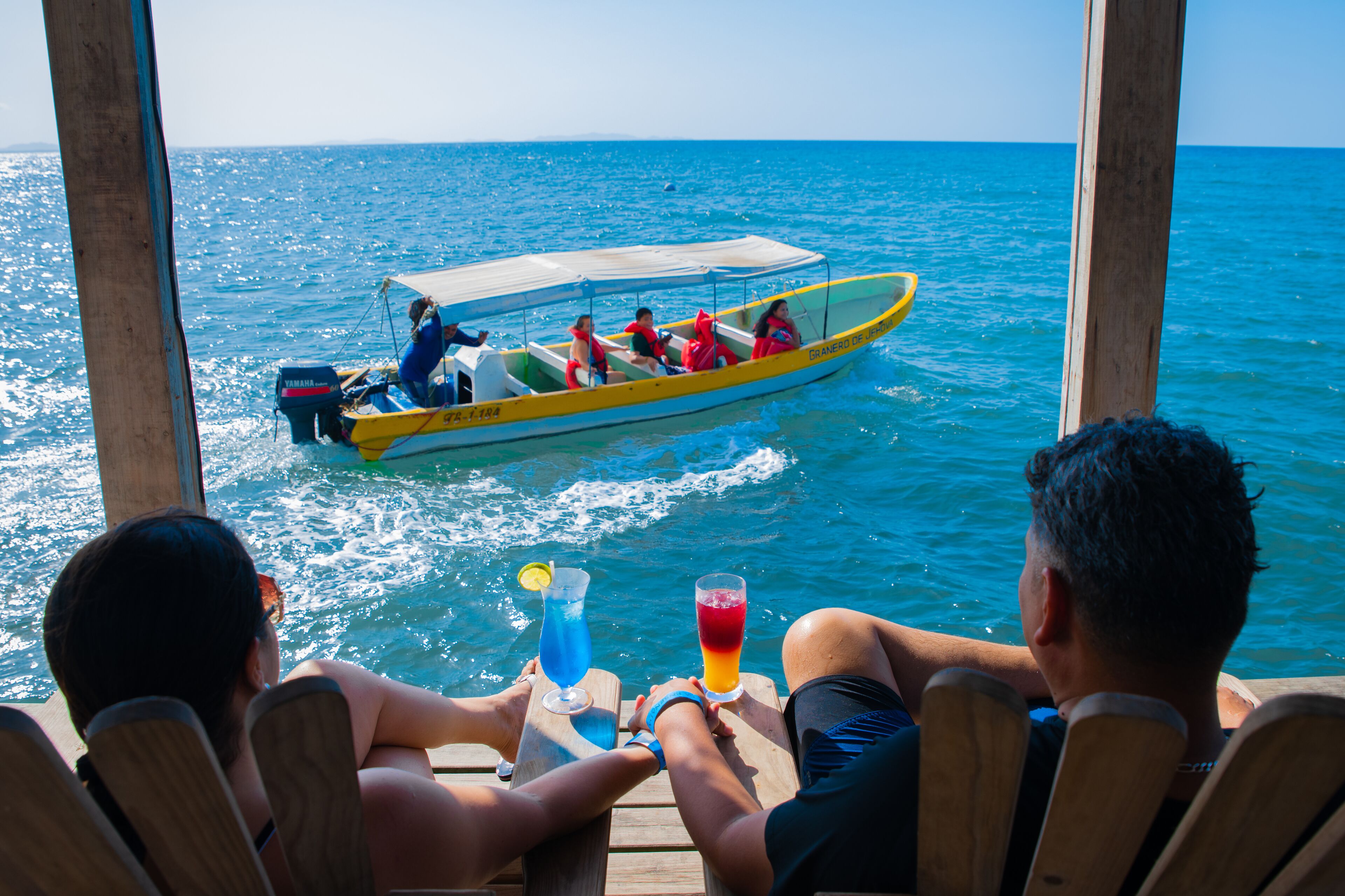 Um barco com passageiros e uma pessoa em outro barco ao fundo.