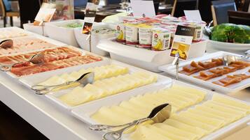Buffet com diversas opções de comida, incluindo carnes, queijos e laticínios.