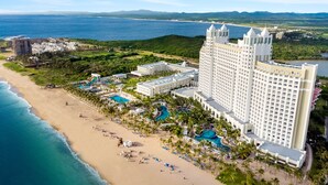 Um resort com uma extensa área de piscina, vários edifícios e uma praia.