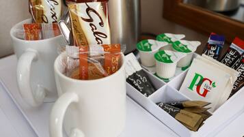 Uma bandeja com xícaras de café, sachês de chocolate quente instantâneo e saquinhos de chá PG tips.