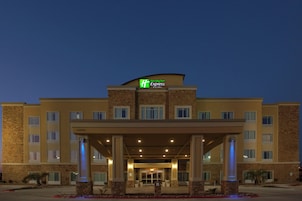Um hotel Holiday Inn Express com entrada coberta, vários andares e fachada de tijolos.
