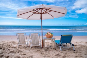 Na praia, praia de areia branca, espreguiçadeiras, guarda-sóis de praia 