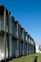 Uma fileira de edifícios modernos com varandas e grandes janelas.