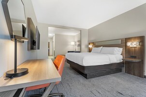 Quarto de hotel moderno com cama, escrivaninha e cadeira.