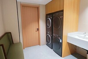 Quarto pequeno com máquina de lavar, pia e porta.