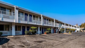 Um motel com várias divisas, cada uma com um número de porta e uma varanda.
