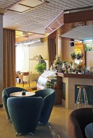Um saguão de hotel com área de bar, assentos e vista para o exterior.