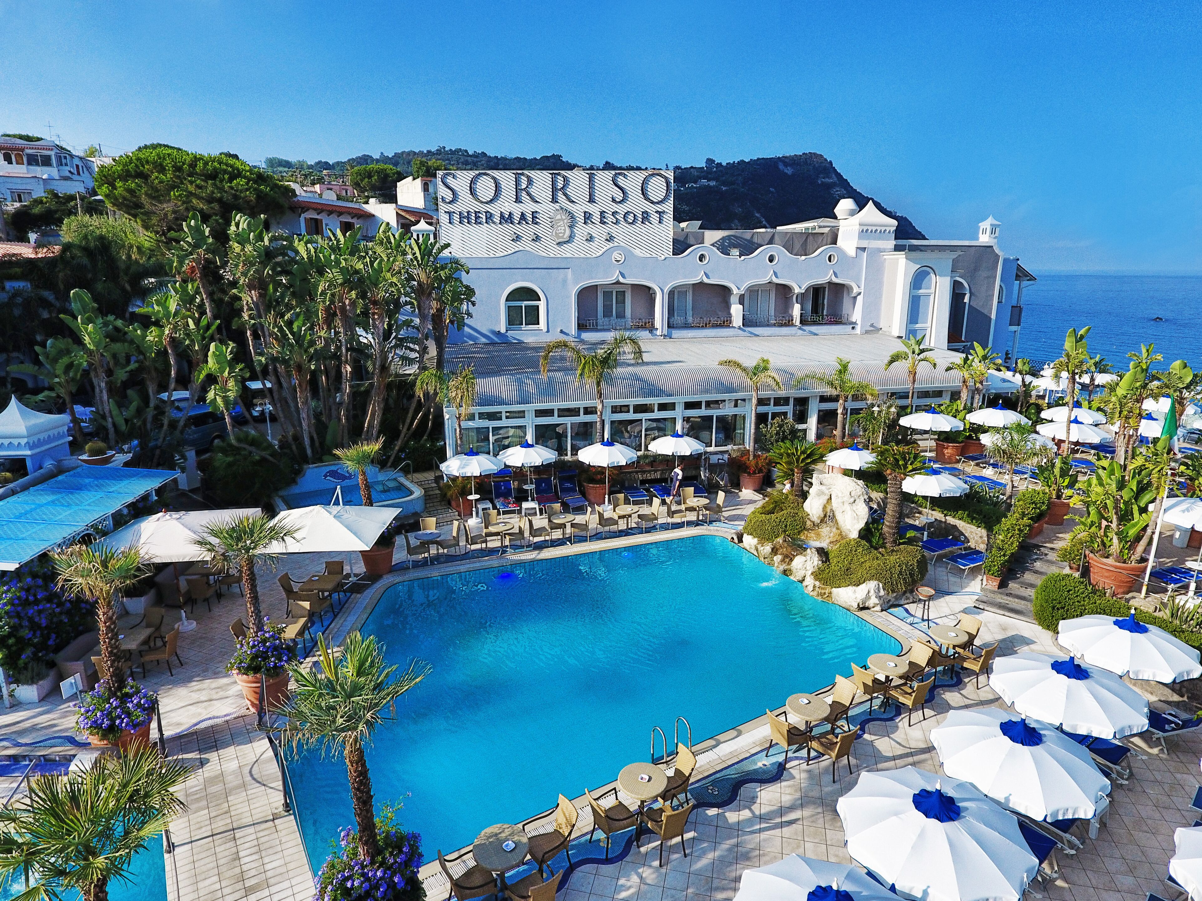 Resort com piscina, espreguiçadeiras e guarda-sóis.
