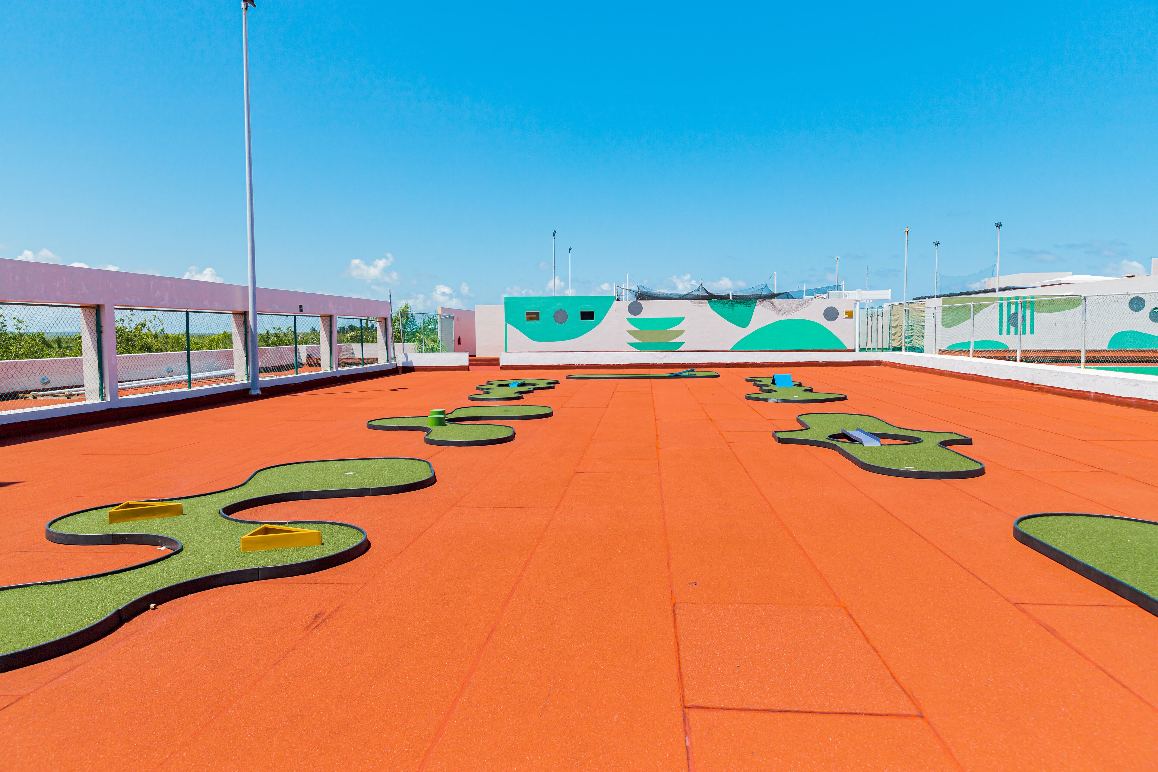 Um terraço no topo com piso estampado, vista para a cidade e um edifício com design singular.