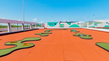 Um terraço no topo com piso estampado, vista para a cidade e um edifício com design singular.