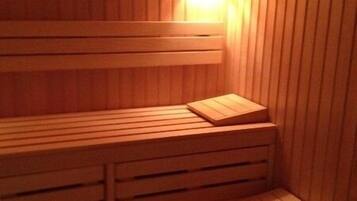 Uma sauna de madeira com bancos e um assento.