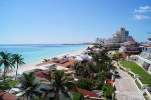 Praia particular, areia branca, espreguiçadeiras, guarda-sóis 