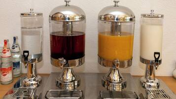Uma estação de distribuição de bebidas com quatro opções diferentes, incluindo água, chá, suco e leite.