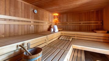 Uma sauna de madeira com bancos e um balde.