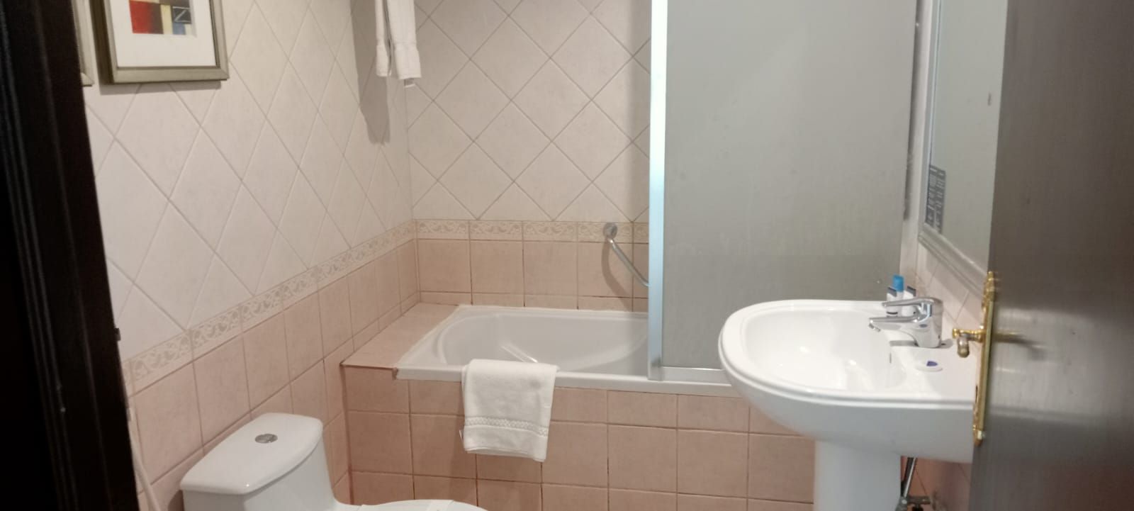 Uma casa de banho com banheira, sanita e lavatório.