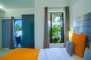 Quarto com cama, cortinas e vista para o exterior.