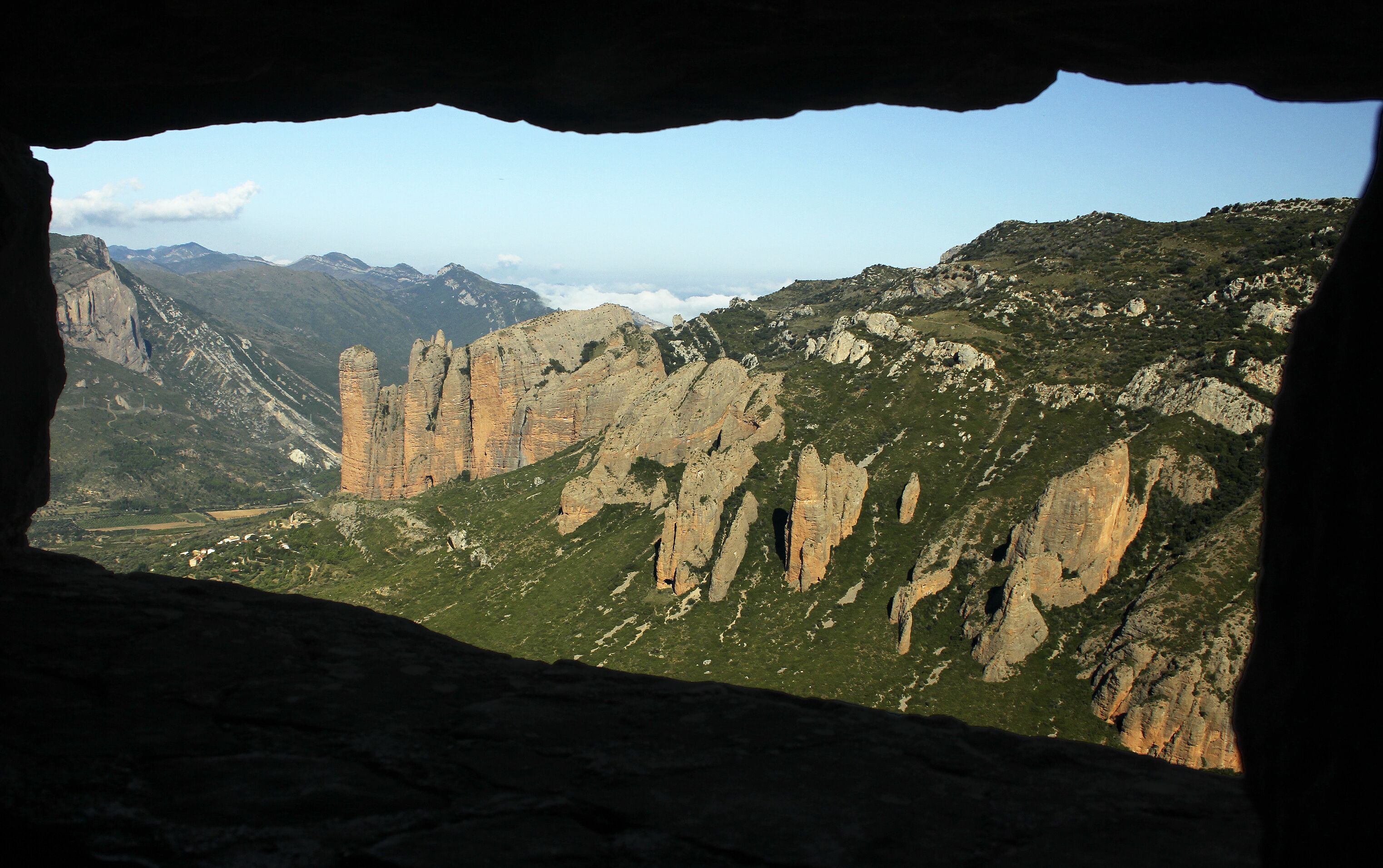 Paisagem montanhosa vista da entrada de uma caverna.