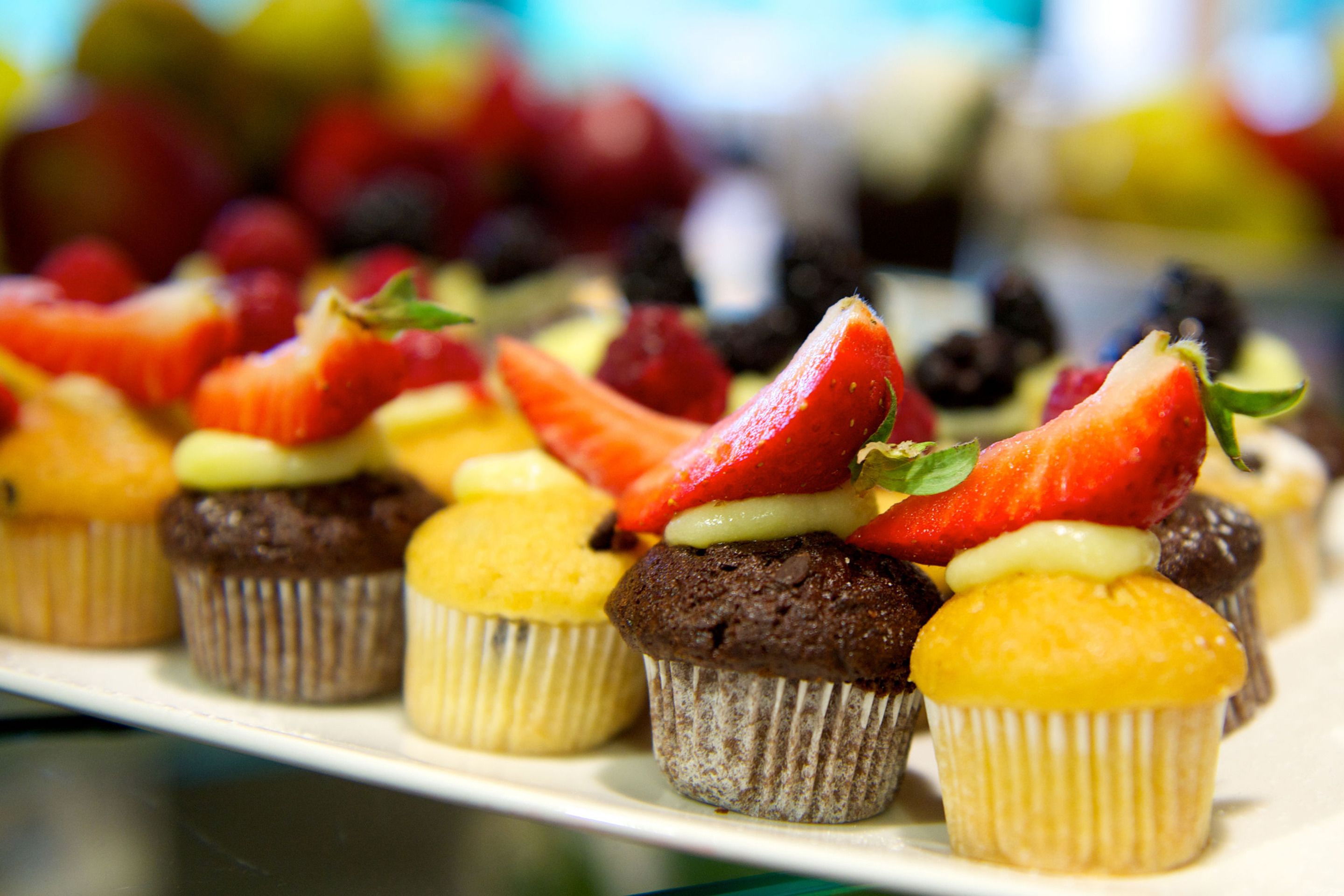 Um prato de cupcakes com diferentes coberturas.