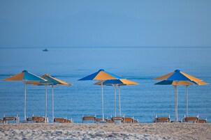 Praia particular, espreguiçadeiras, guarda-sóis 