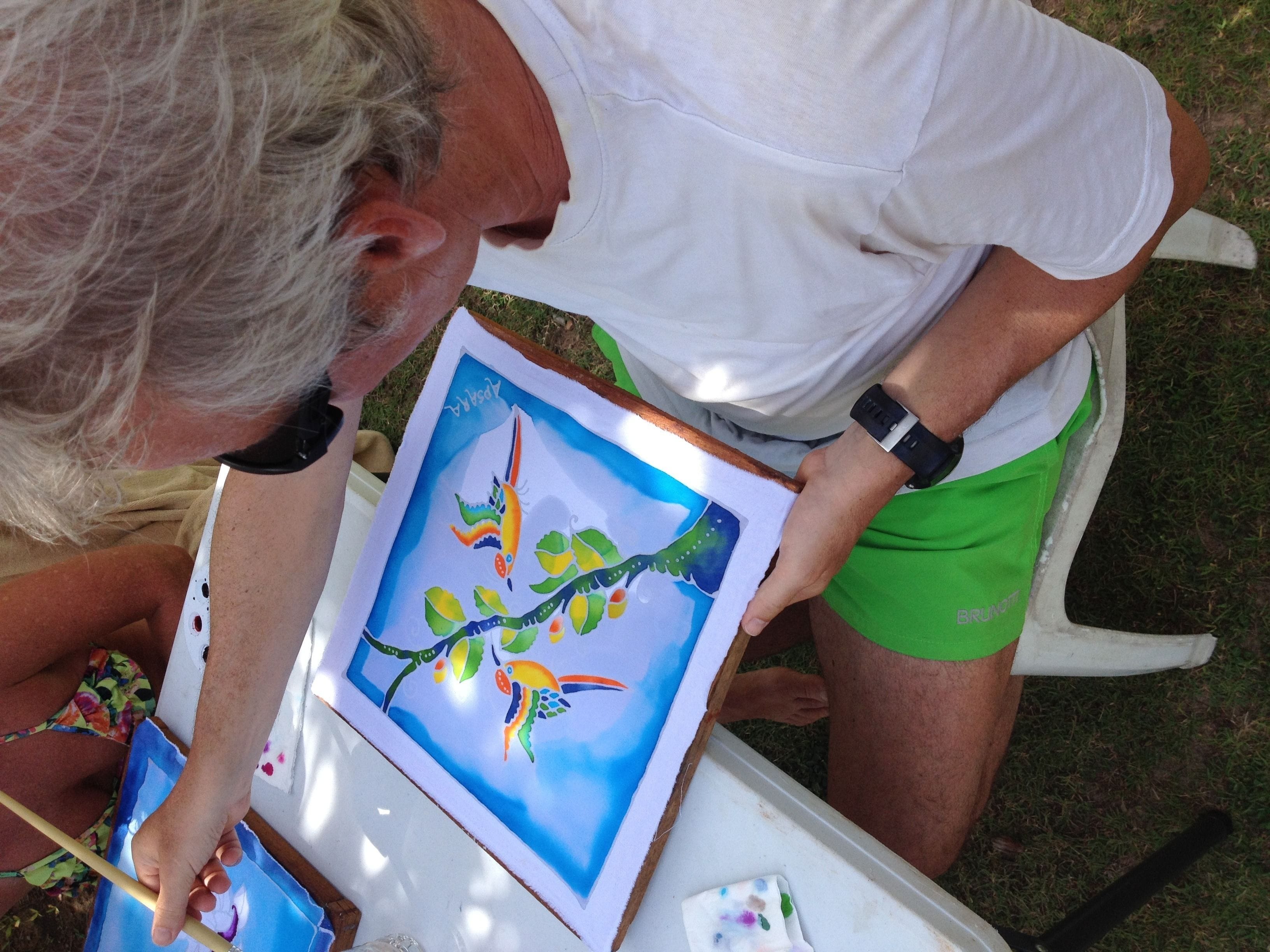 Uma pessoa pintando uma obra de arte colorida em uma tela.