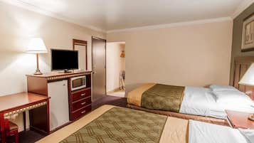 Quarto de hotel com duas camas, uma escrivaninha com televisão, micro-ondas e um guarda-roupa.