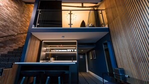 Cozinha moderna com área de bar, escada e vista da cidade.