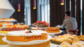 Buffet com diversos doces, incluindo bolos, pastéis e frutas.