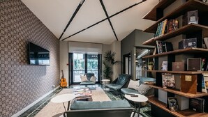 Uma sala de estar moderna com um sofá, poltronas, uma mesa de centro e uma estante de livros.