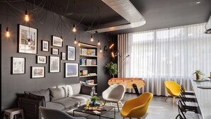 Uma sala de estar moderna com um sofá, cadeiras, uma mesa de centro e um bilhar.