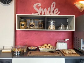 Uma bancada de cozinha com potes de lanches, uma torradeira e pão.