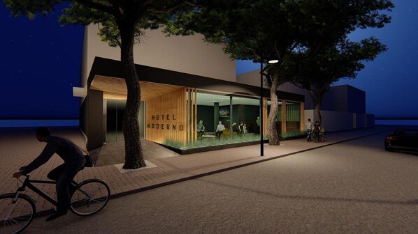 Um hotel moderno com fachada de vidro, exterior de madeira e uma bicicleta estacionada na frente.