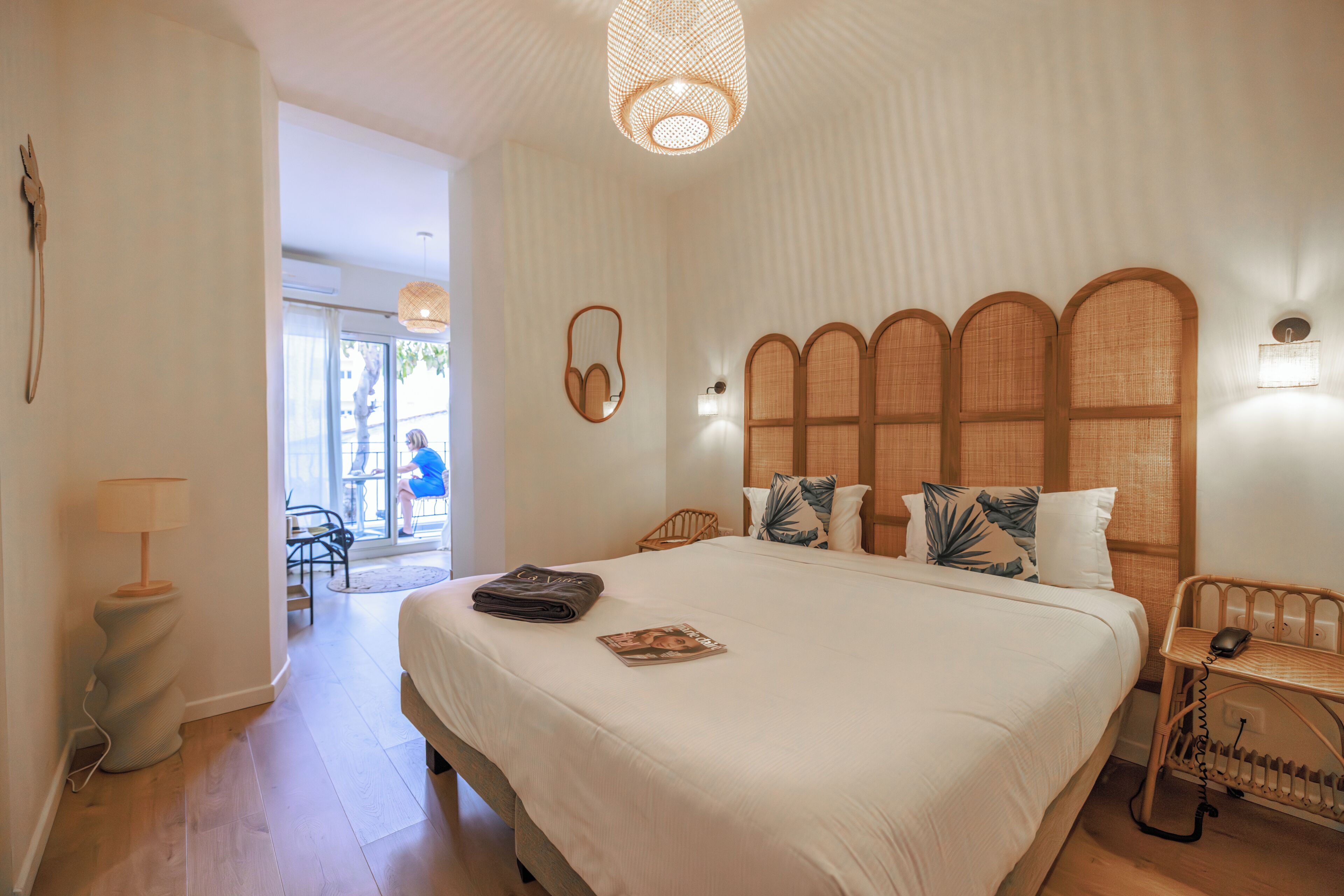 Quarto com cama grande, mesa de cabeceira, abajur e janela.