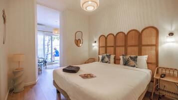 Quarto com cama grande, mesa de cabeceira, abajur e janela.