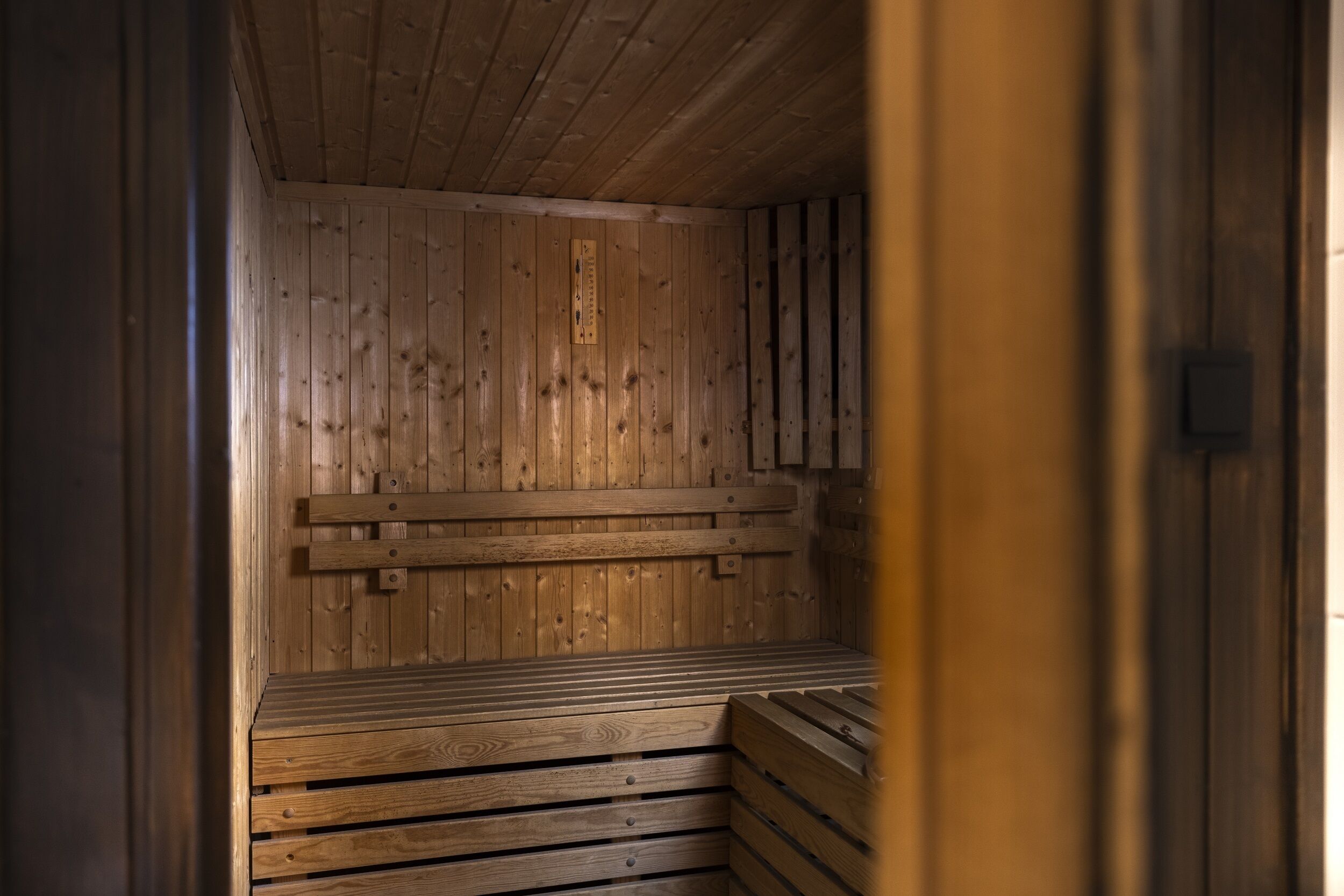 Uma sauna com bancos de madeira e teto inclinado.