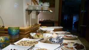 Uma mesa de buffet com diversos alimentos e utensílios.
