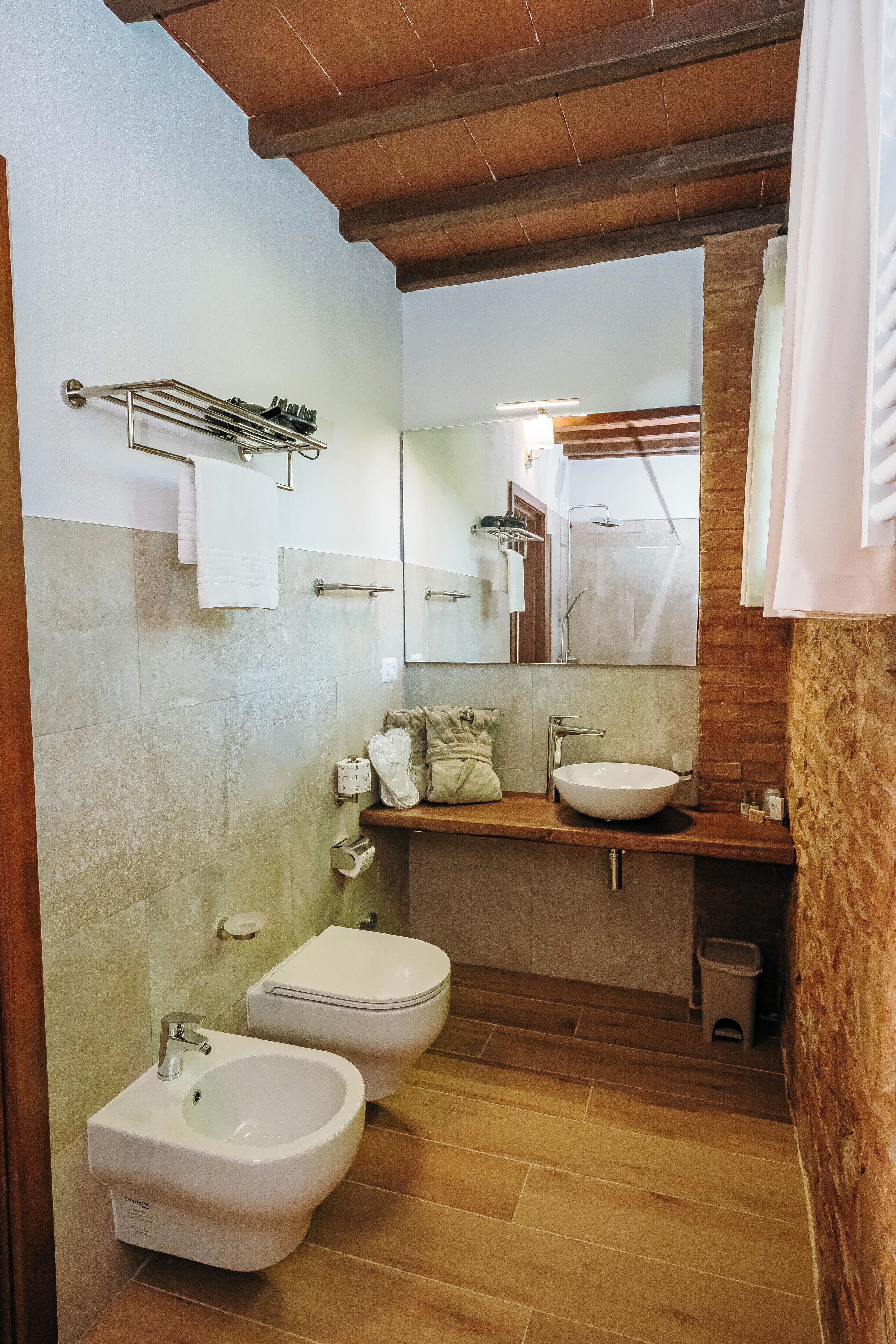 Casa de banho com duas pias, um espelho e um porta-toalhas.