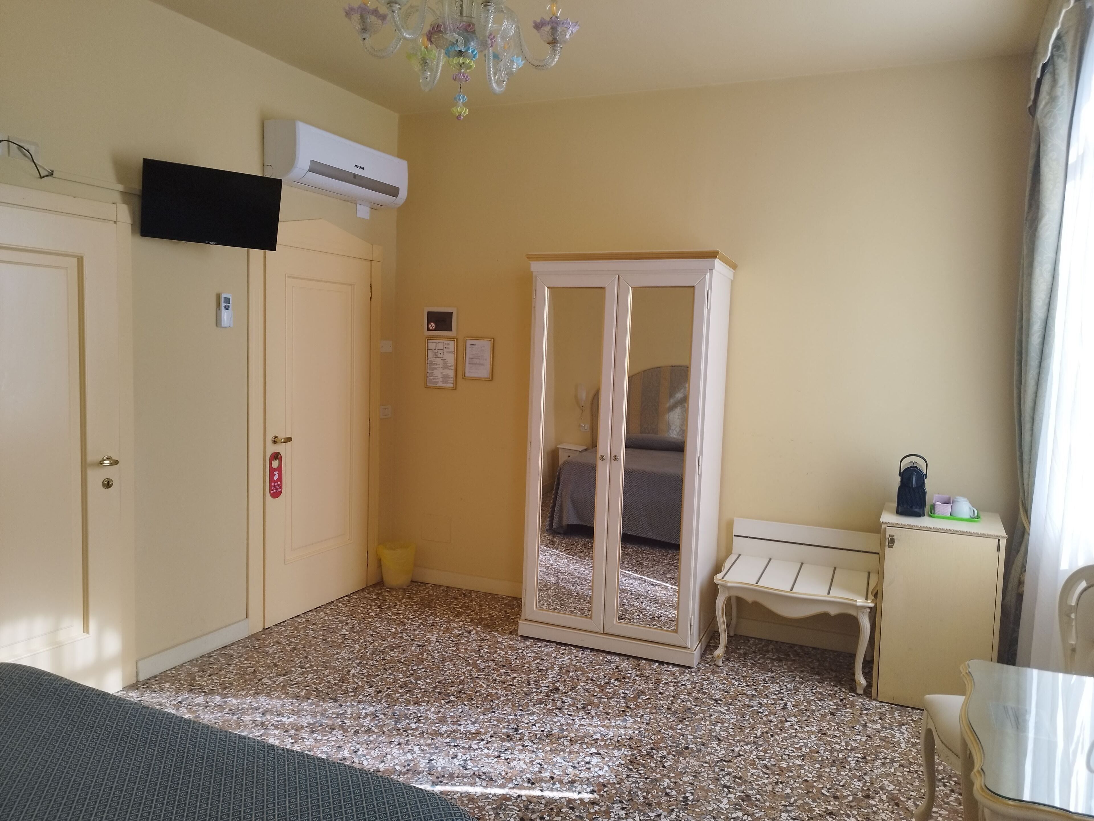 Um quarto com uma cama, um guarda-roupa, uma escrivaninha e uma cadeira.