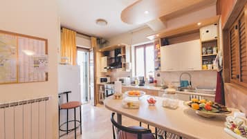 Uma placa de cozinha, uma cafeteira/bule, utensílios de cozinha