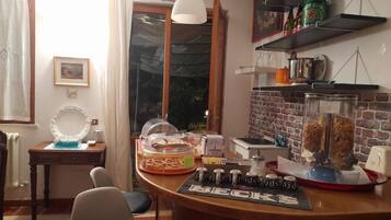 Cozinha com painel de ladrilho, bancada de madeira e diversos eletrodomésticos e utensílios.