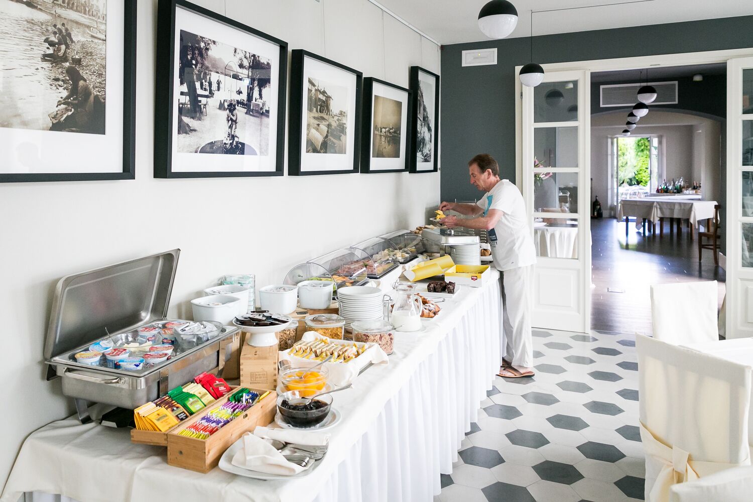 Buffet montado com diversos alimentos e uma pessoa servindo.