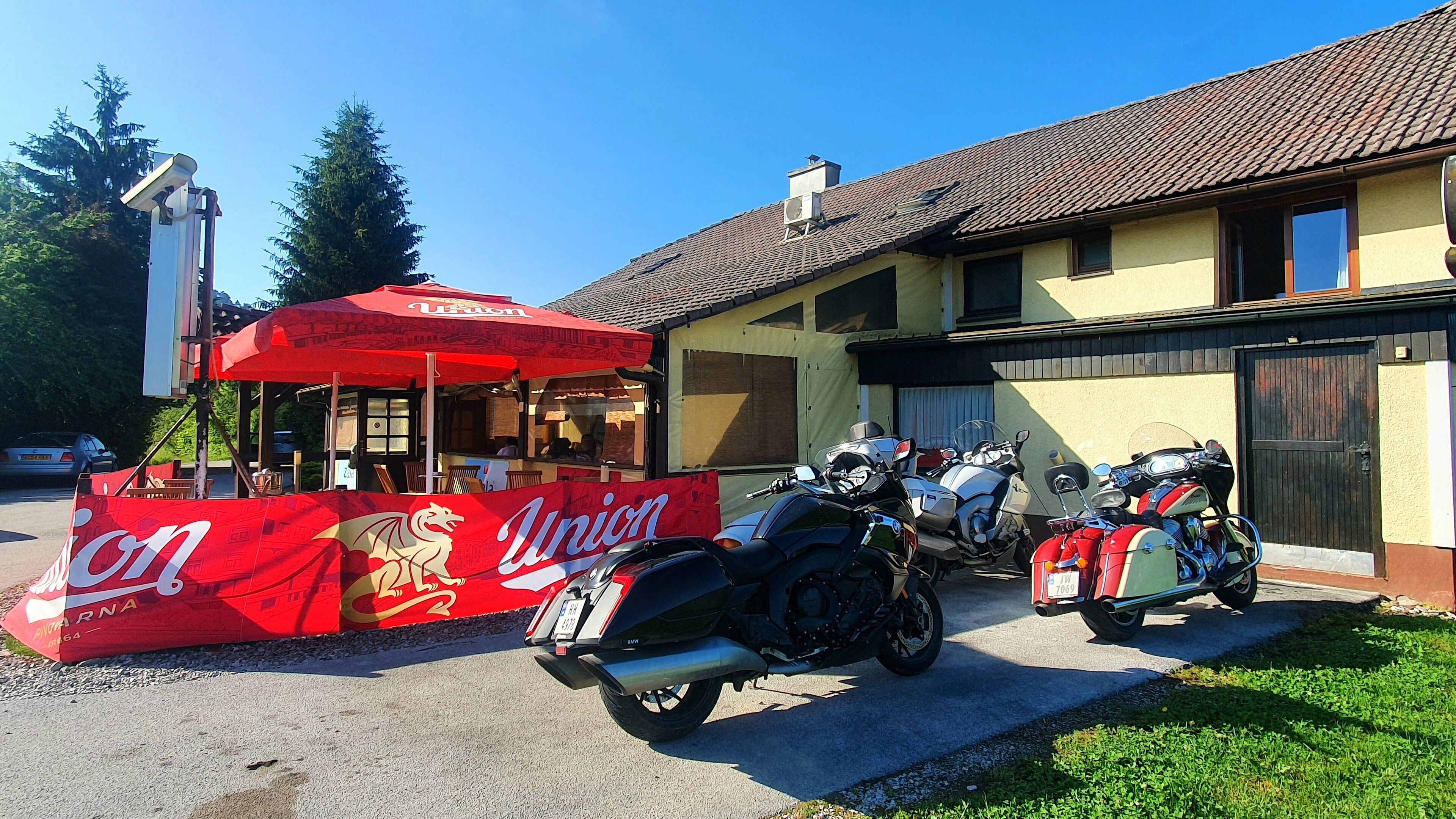 Um edifício com telhado telhado e uma motocicleta estacionada na frente.