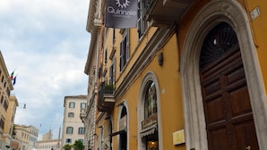 Um edifício com uma placa indicando 'Quirinale Luxury Rooms'.