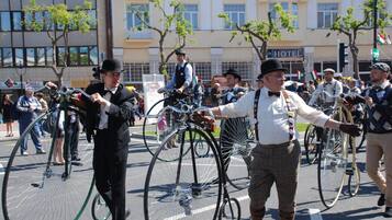 Um hotel com uma placa, rodeado por uma multidão de pessoas e bicicletas.