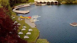Hotel na beira do lago com área de natação, um pavilhão coberto e um cais para barcos.