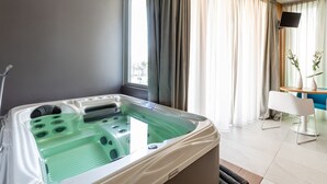 Um banheiro moderno com uma banheira grande, área de chuveiro e uma janela com cortinas.