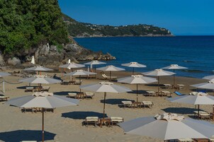 Praia particular, areia branca, espreguiçadeiras, guarda-sóis 