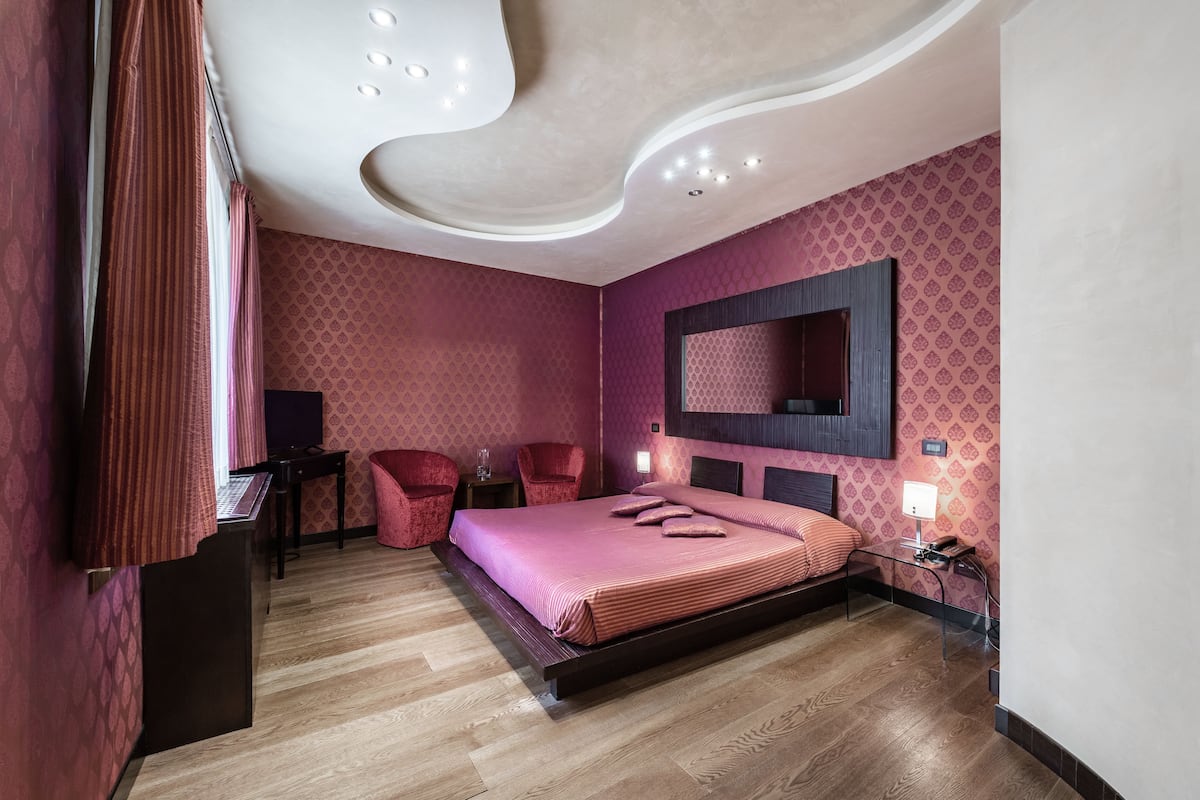 Quarto moderno com uma cama grande, uma escrivaninha e duas cadeiras.