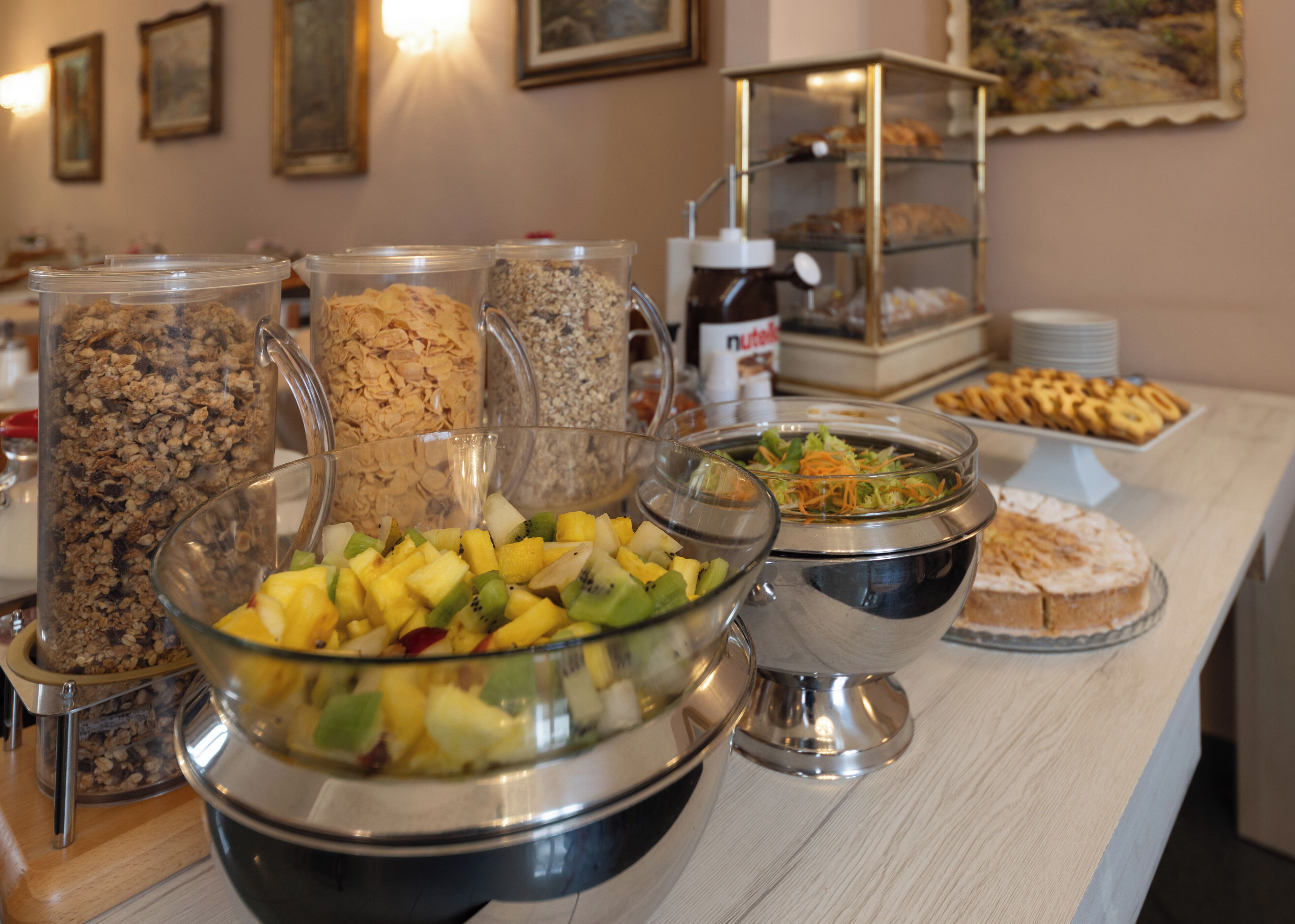 Um buffet com diversas opções de comida, incluindo frutas, saladas e doces.
