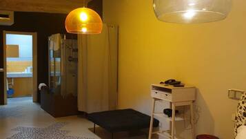 Um quarto com uma cama, mesa de cabeceira e luminária suspensa.