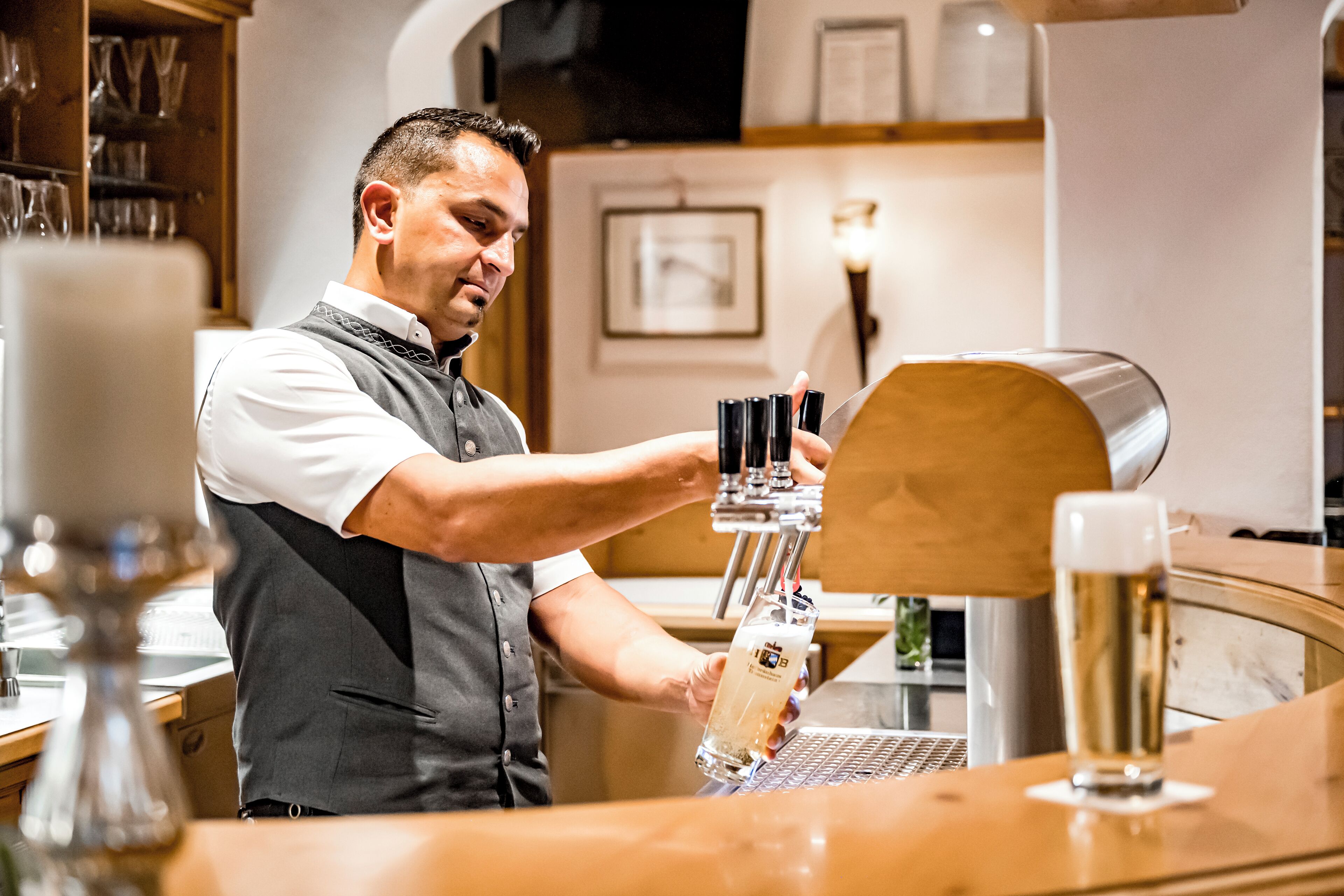Um barman servindo uma bebida de uma torneira.
